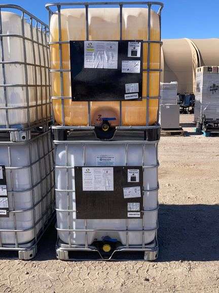 (2) 275 gallon liquid containers with protective metal cage and drain ...