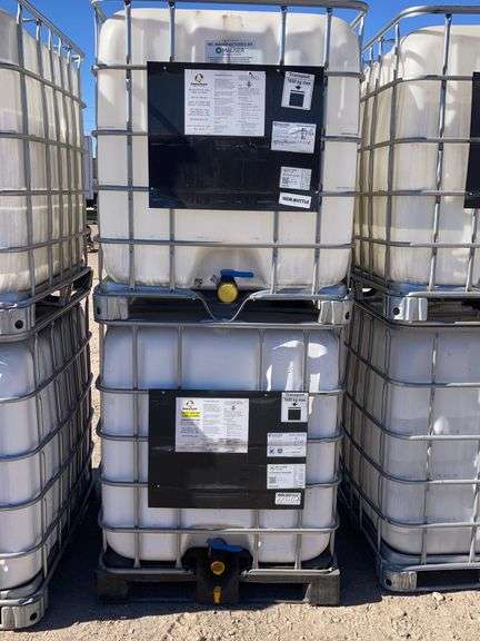 (2) 275 gallon liquid containers with protective metal cage and drain ...