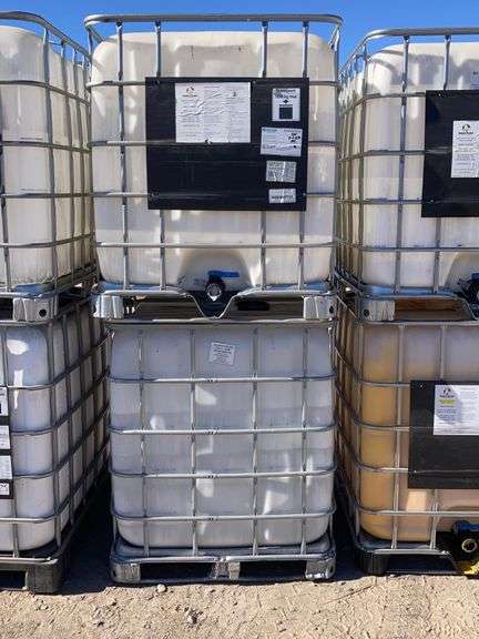 (2) 275 gallon liquid containers with protective metal cage and drain ...