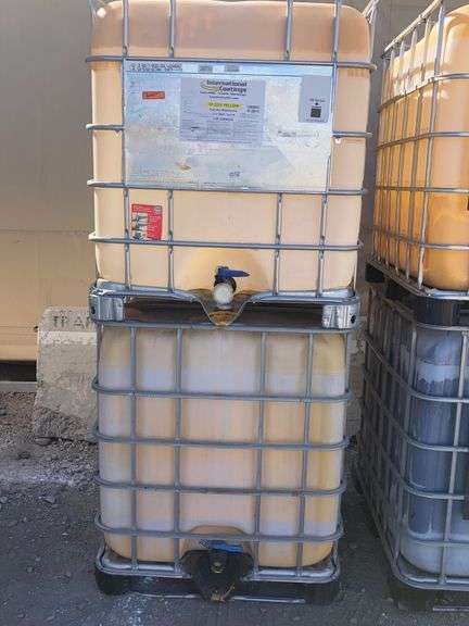 (2) 275 gallon liquid containers with protective metal cage and drain ...