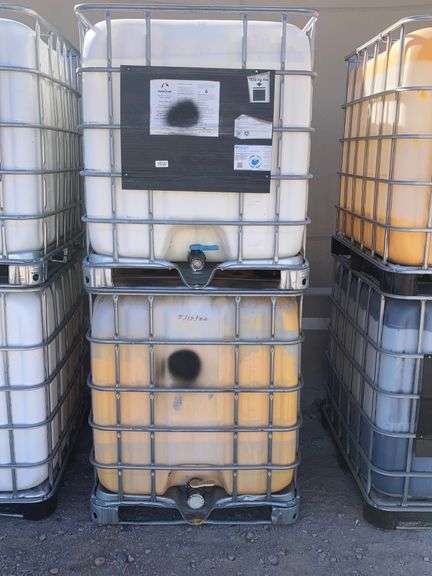 (2) 275 gallon liquid containers with protective metal cage and drain ...