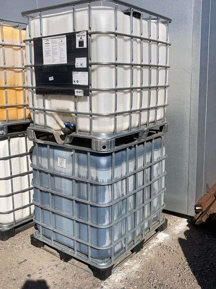 (2) 275 gallon liquid containers with protective metal cage and drain ...