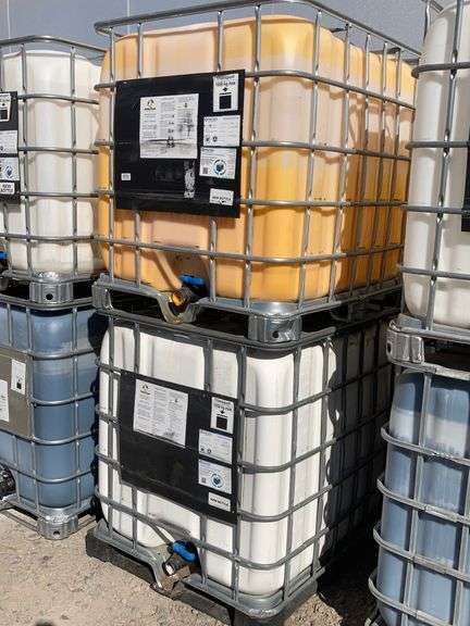 (2) 275 gallon liquid containers with protective metal cage and drain ...