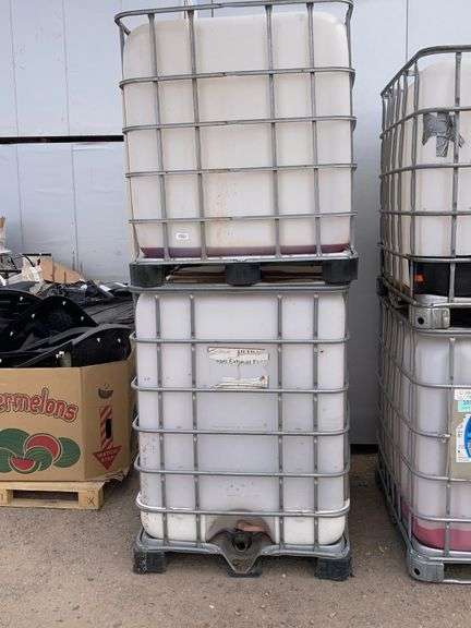 (2) 275 gallon liquid containers with protective metal cage and drain ...