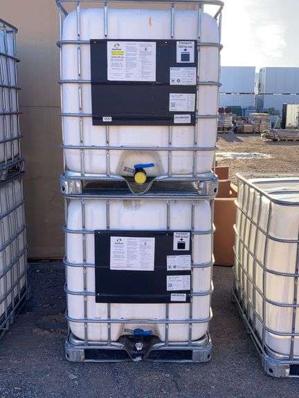 (2) 275 gallon liquid containers with protective metal cage and drain ...