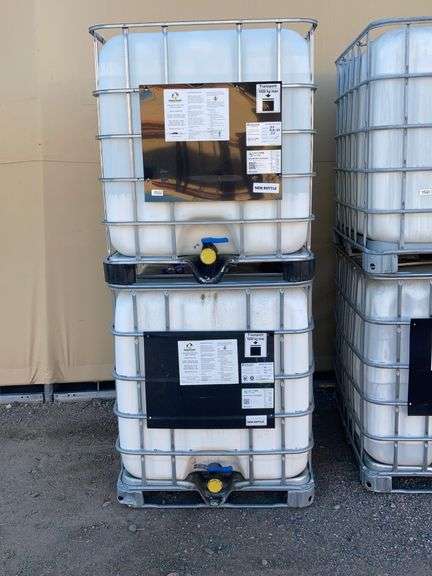 (2) 275 gallon liquid containers with protective metal cage and drain ...