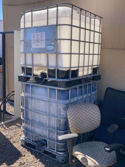 (2) 250 gallon liquid containers with protective metal cage and drain ...