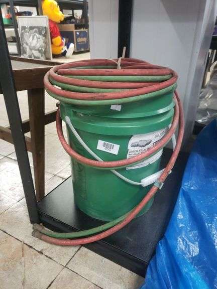 Green bucket with coiled red hose - Trice Auctions